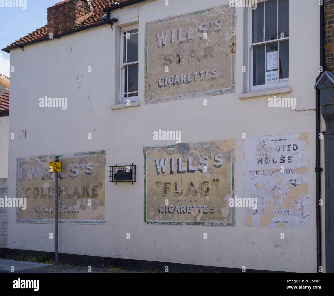 Old and peeling painted Wills's cigarette advertisements on the wall of ...