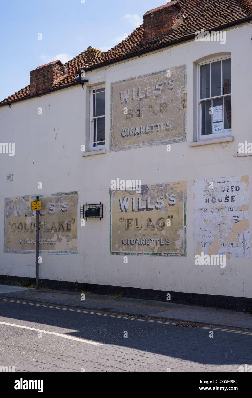 Old and peeling painted Wills's cigarette advertisements on the wall of ...