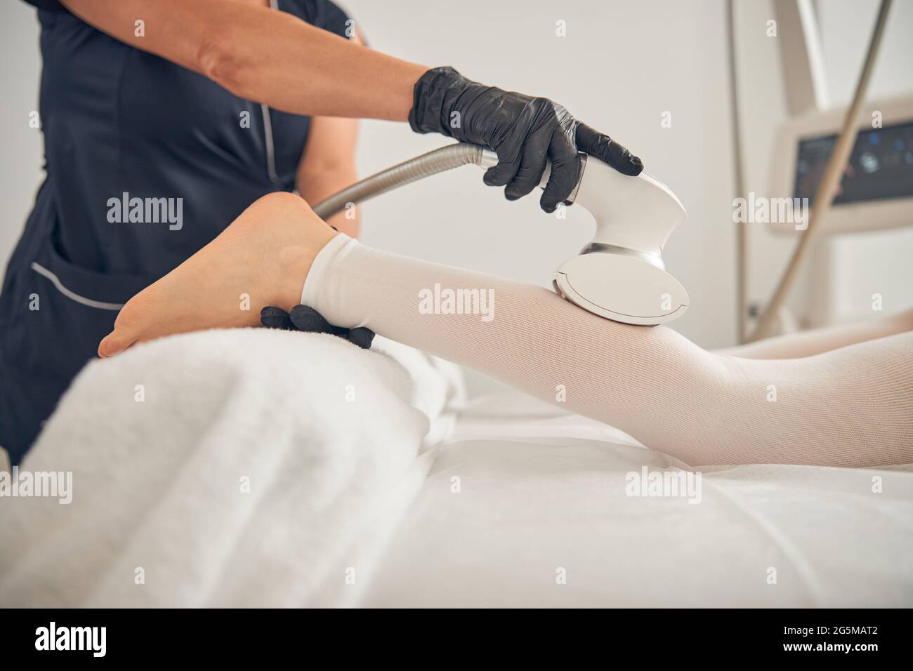 Using special device for reducing fat on legs Stock Photo - Alamy