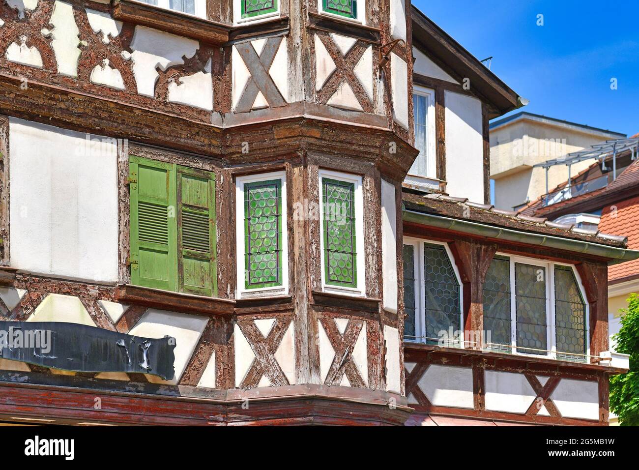 Oriel and windows with green shutters of old European style half ...