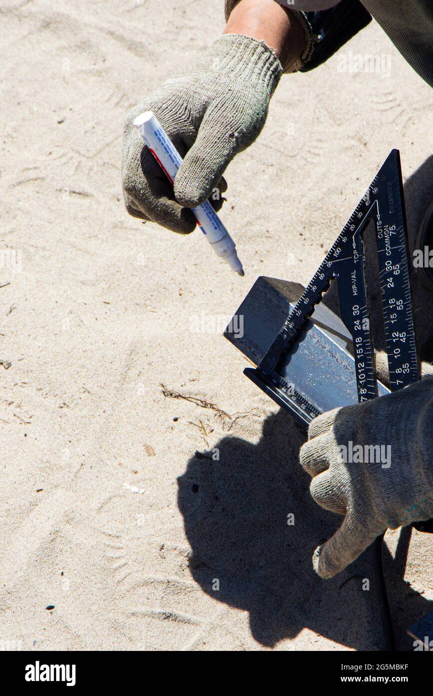 A worker marks the cut line on a piece of metal Stock Photo - Alamy