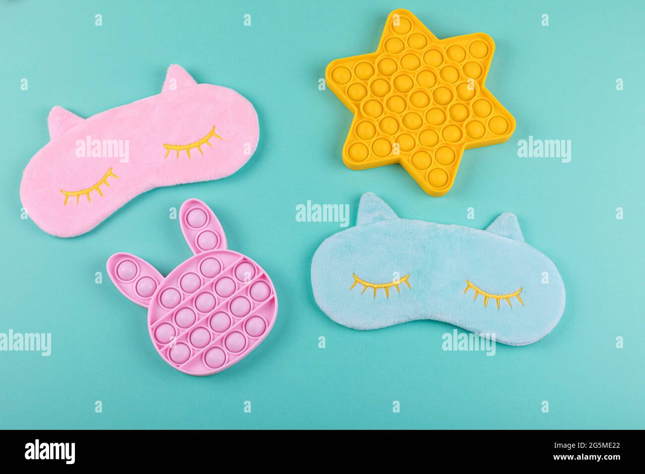 Sleep masks and trendy pop it fidget toys on the mint background ...