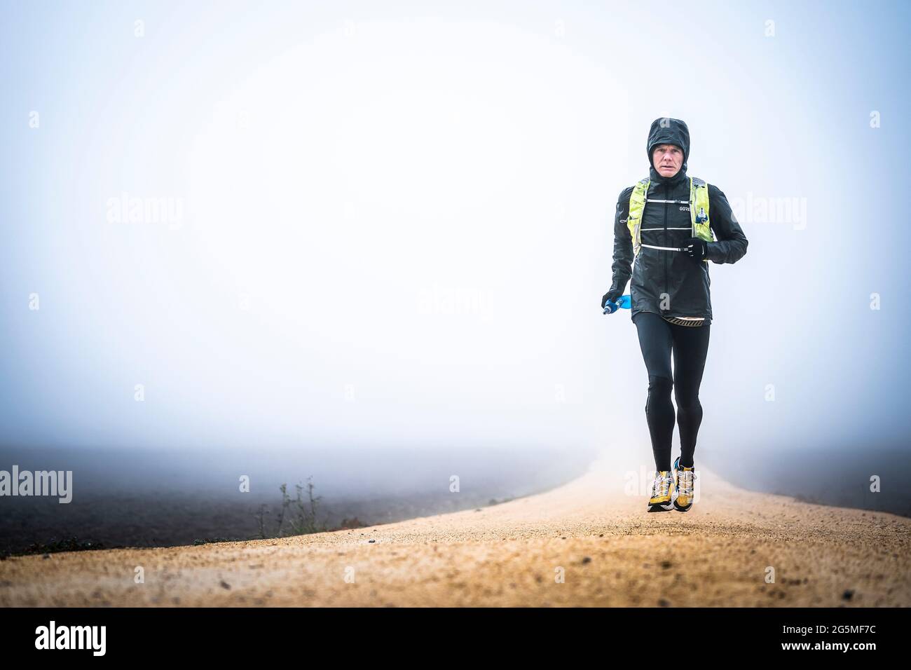 Runner running in cold and foggy winter Stock Photo - Alamy