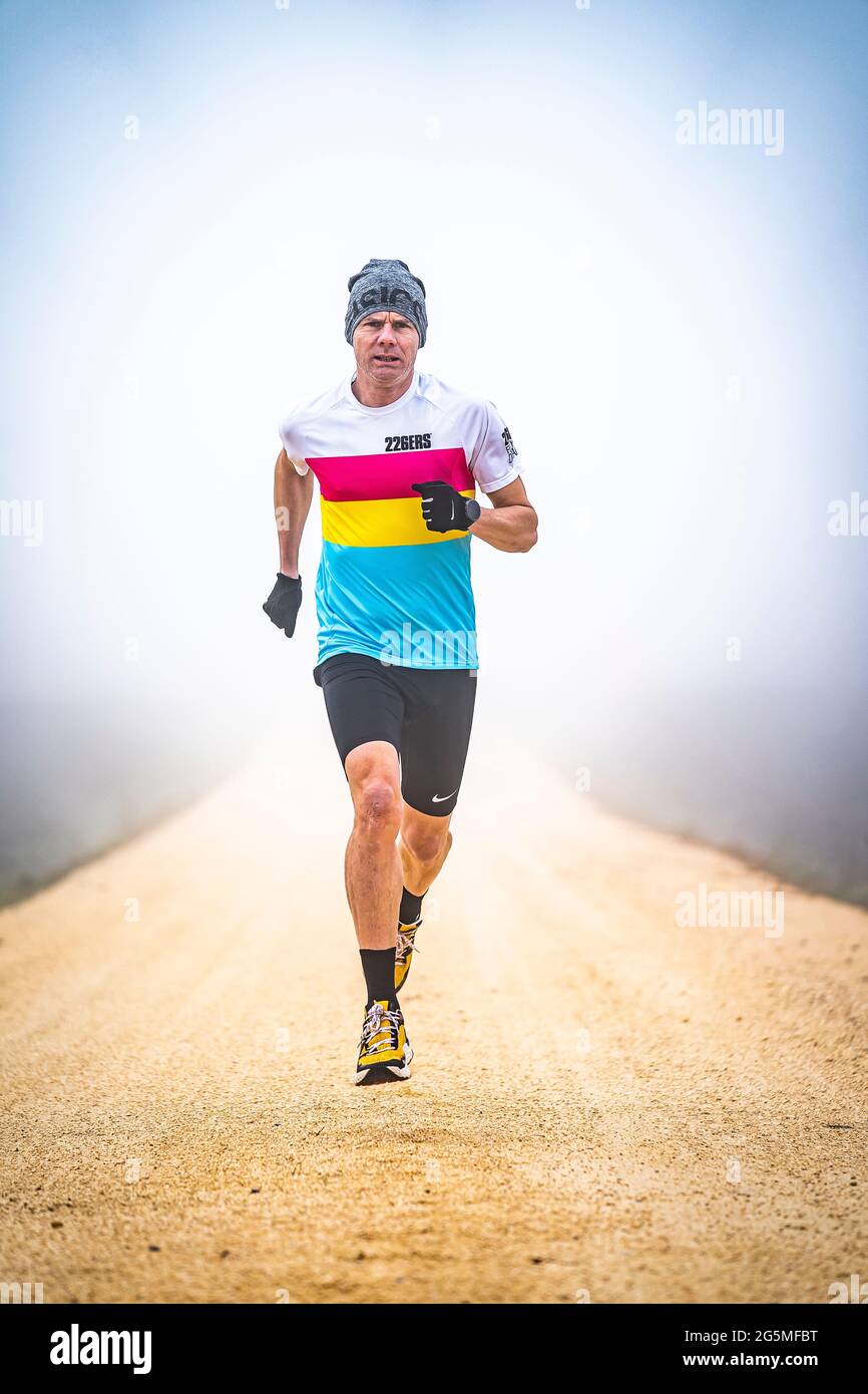 Runner running in cold and foggy winter Stock Photo - Alamy