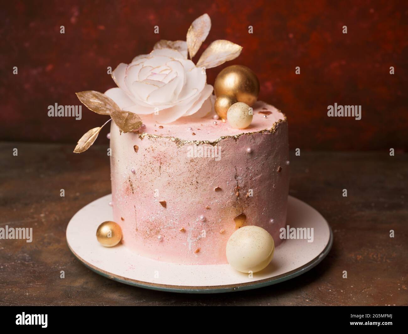 A modern cake decorated with wafer paper flower and golden balls Stock ...