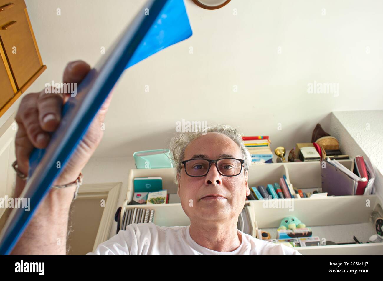 mature man in room placing a notebook in a drawer seen from inside ...