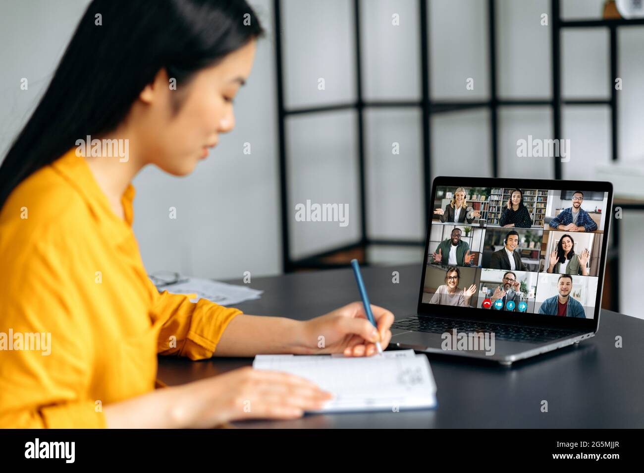 A smart asian female student gains knowledge, listens to an online ...