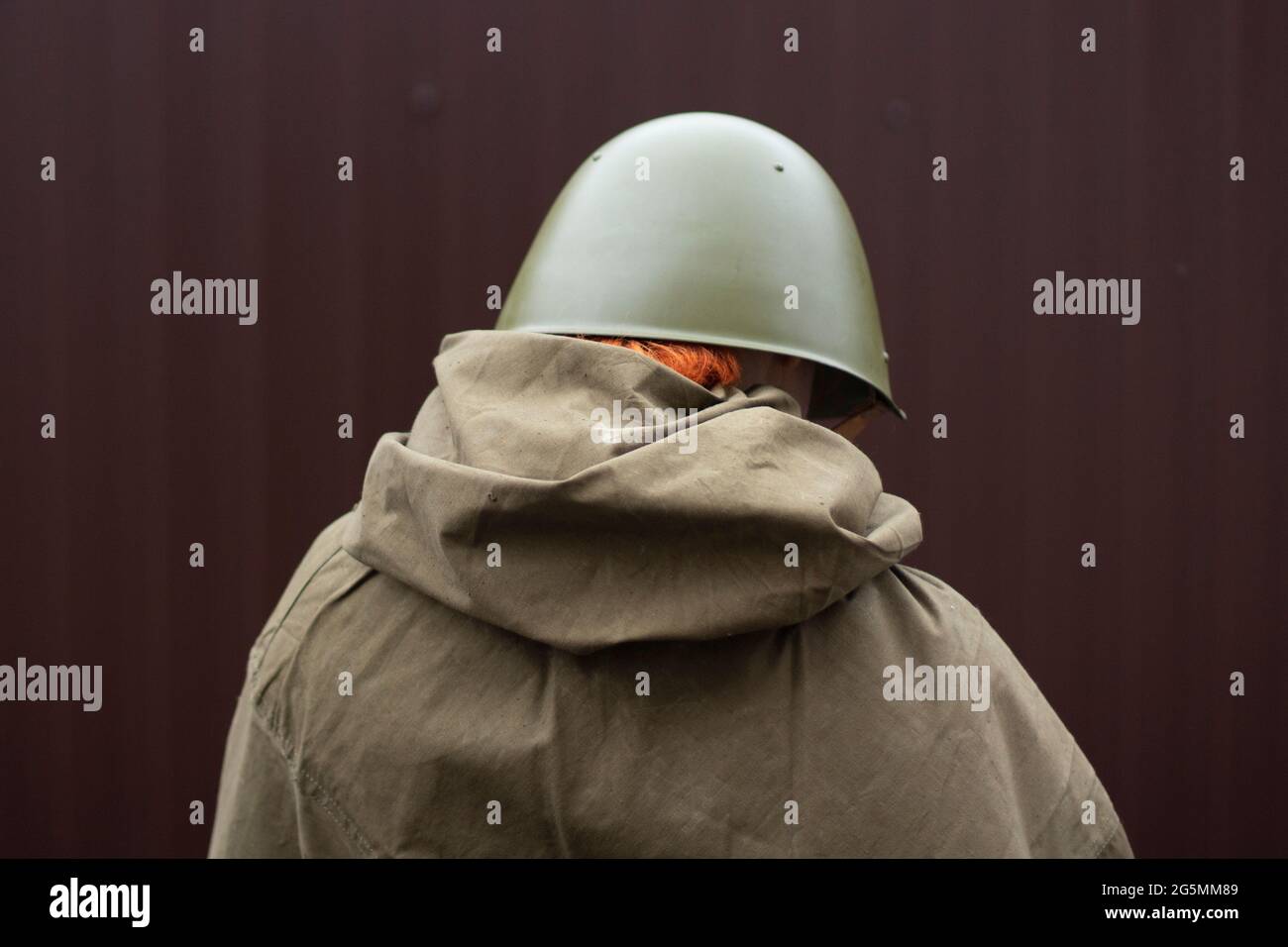 A soldier in a helmet from the back. Old Soviet military uniform. A ...
