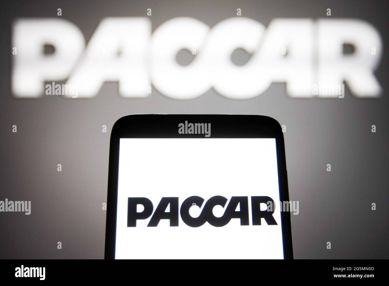In this photo illustration, PACCAR logo is seen on a smartphone and a ...