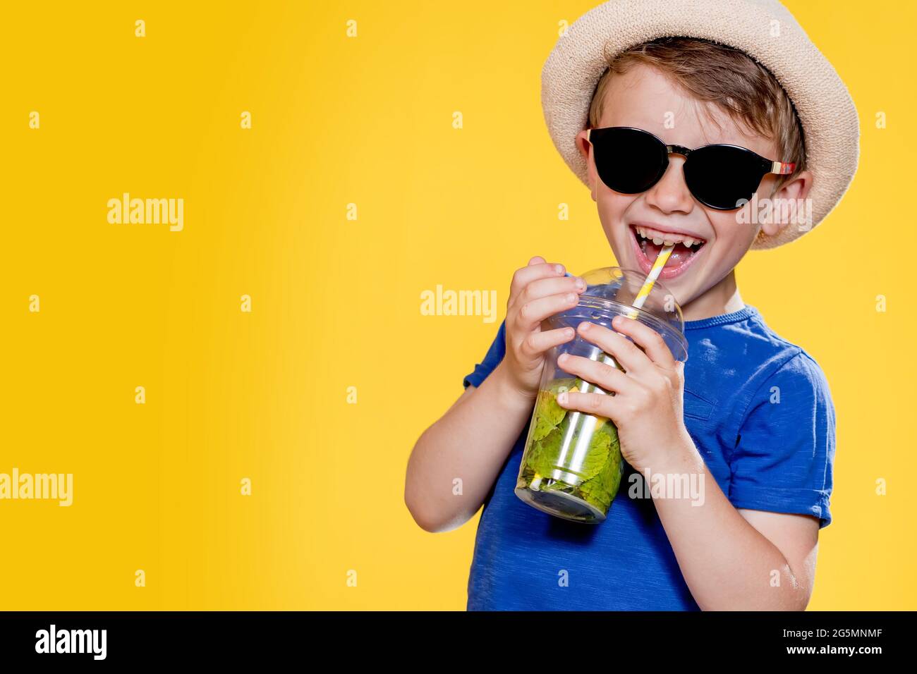 Cute boy Drink Mojito cocktail From Plastic Cup Over Yellow Studio ...