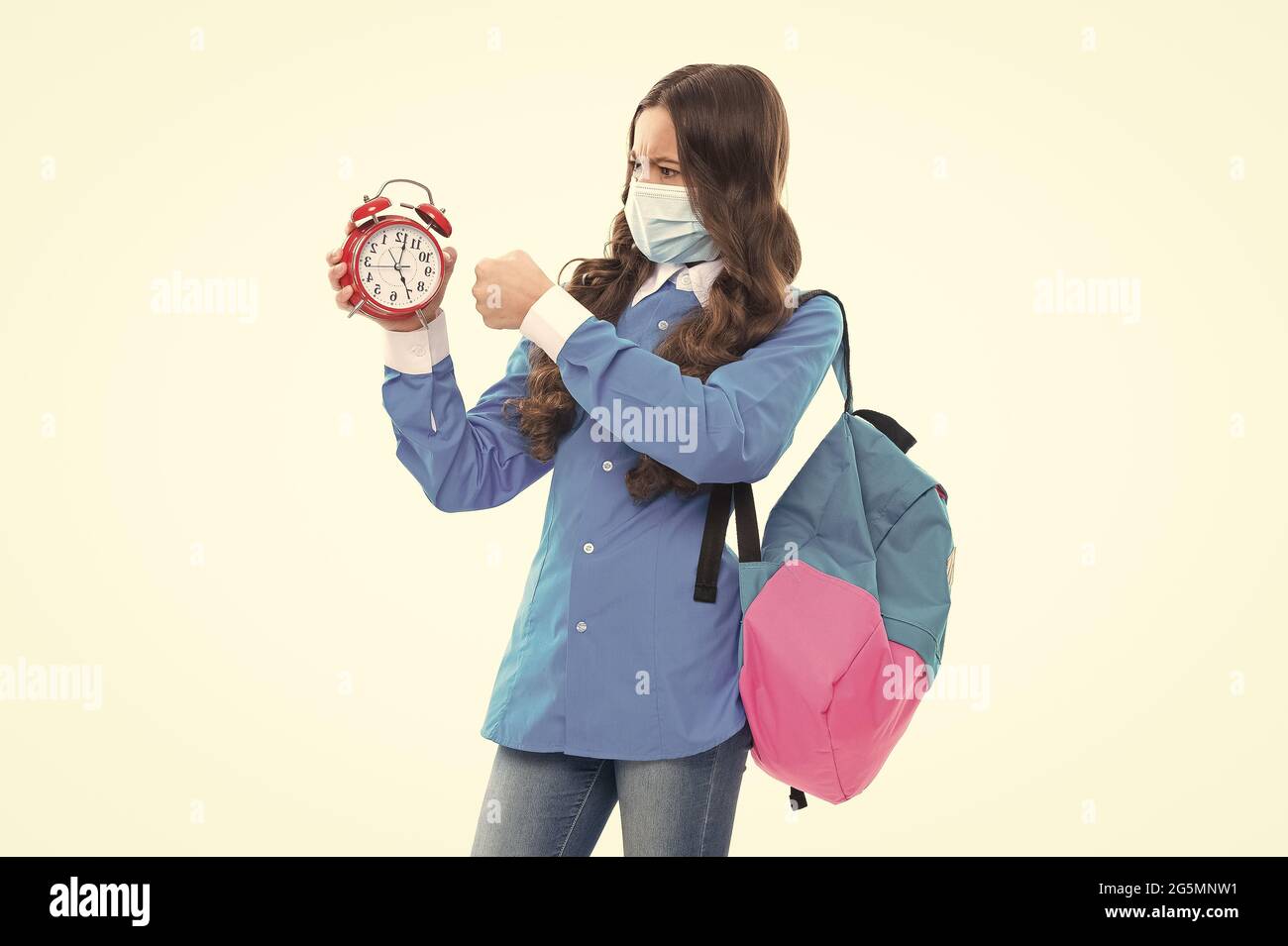 Angry school child in face mask punch alarm clock during COVID-19 ...