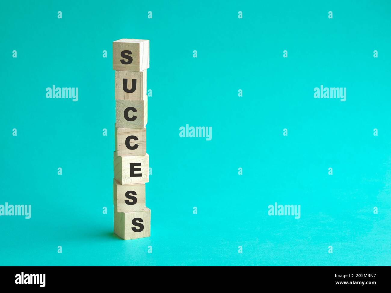 Word Success on wooden cubes stacked in pillar form. Blue background ...