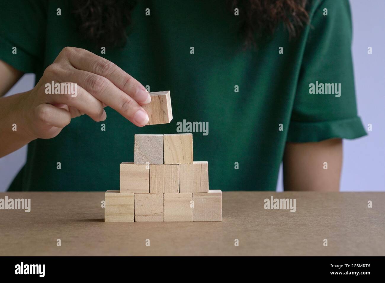 Woman hand arranging wood block stacking as step stair. Business growth ...