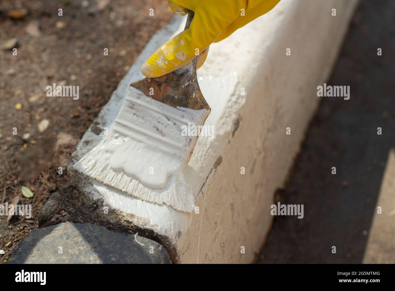 Painting borders with white paint. Applying oil paint to asphalt ...