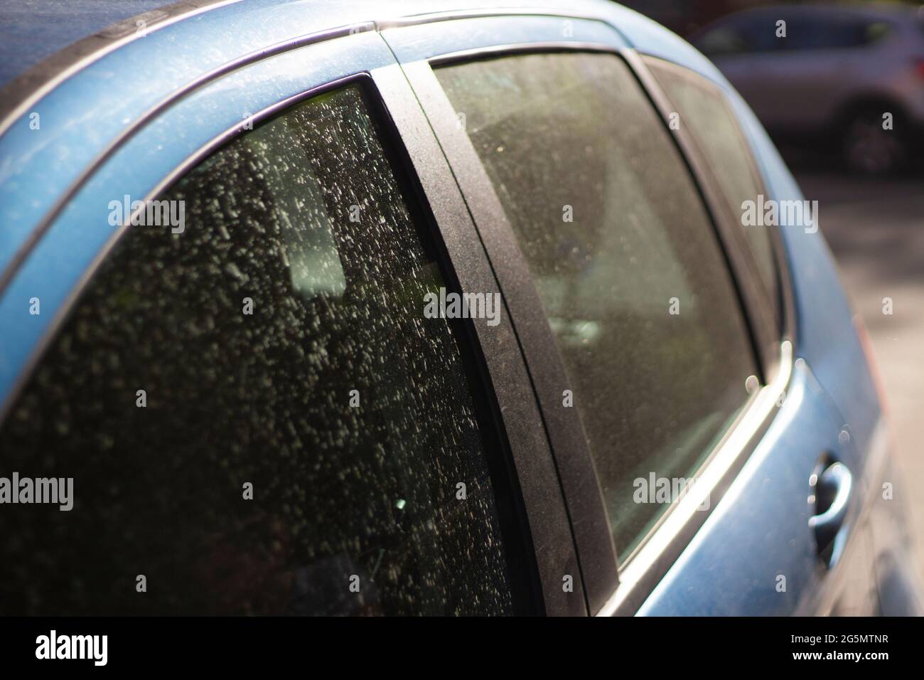 Dirty car side window. Dust on the windshield. The blue car is in the ...