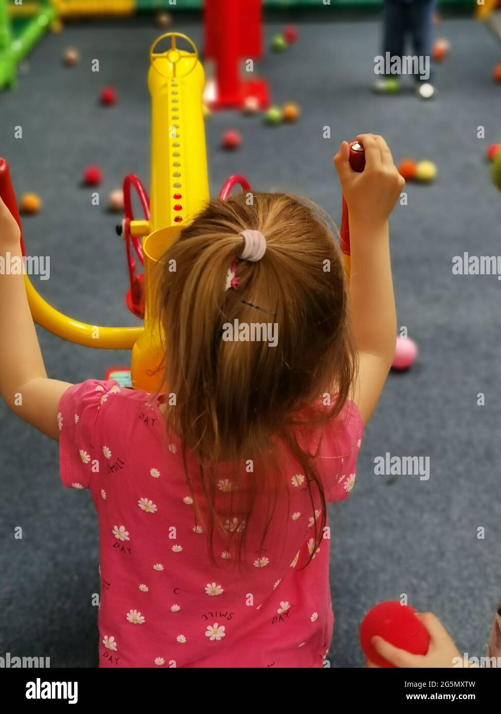 Vertical back view of a female child using a toy at kindergarten Stock ...
