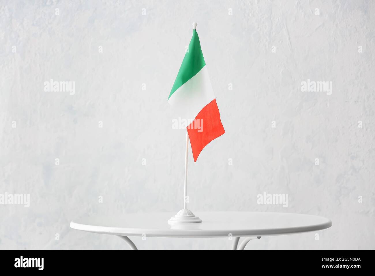 Italian flag on table against white background Stock Photo - Alamy