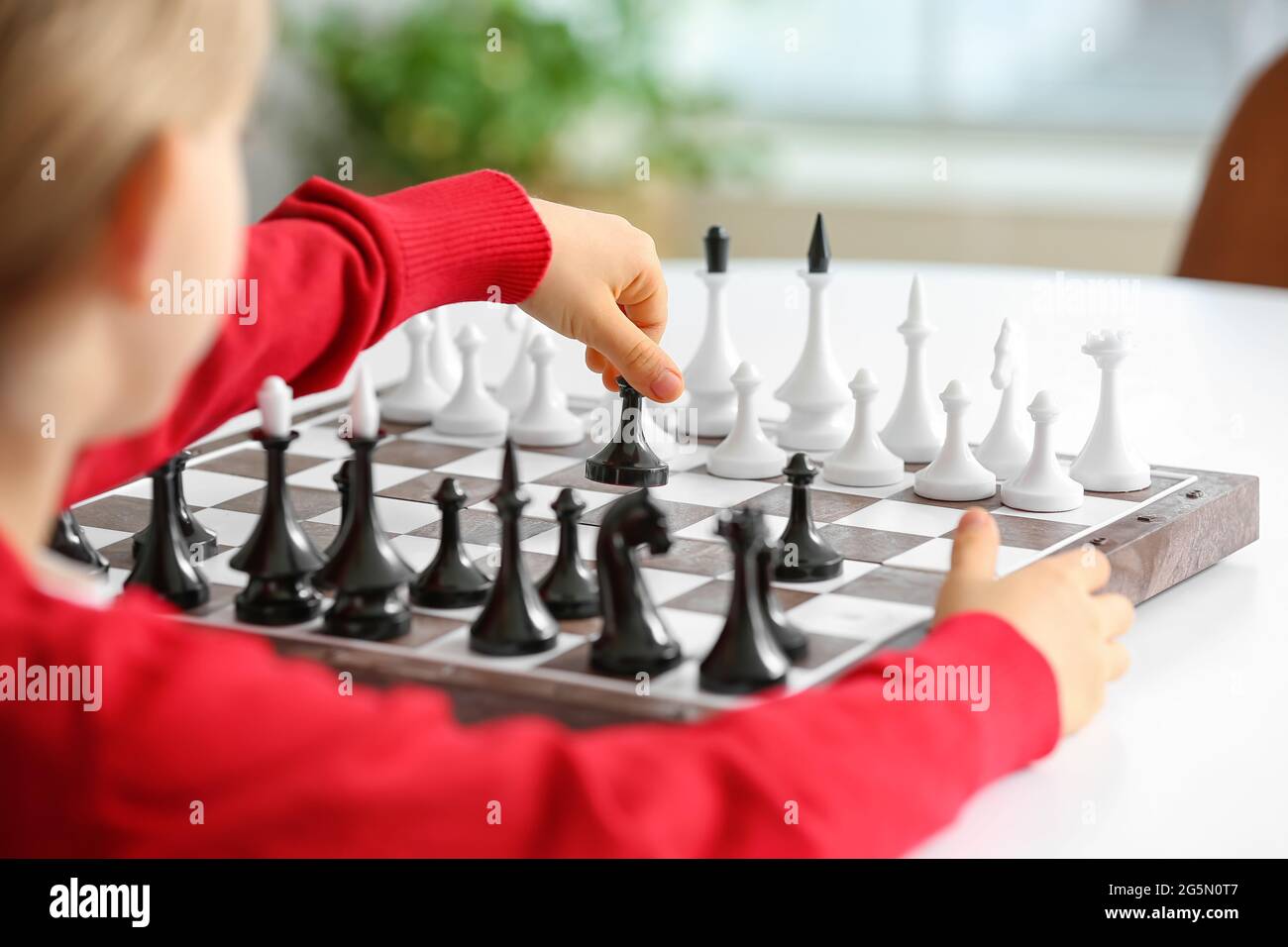 Cute little girl playing chess at home Stock Photo - Alamy