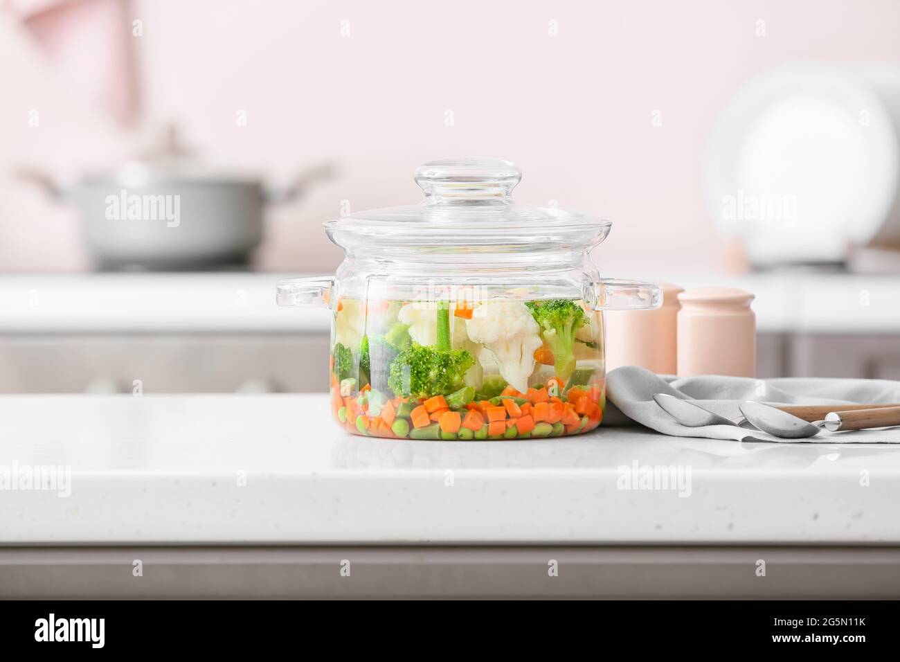 Stylish cooking pot with tasty soup on kitchen counter Stock Photo - Alamy