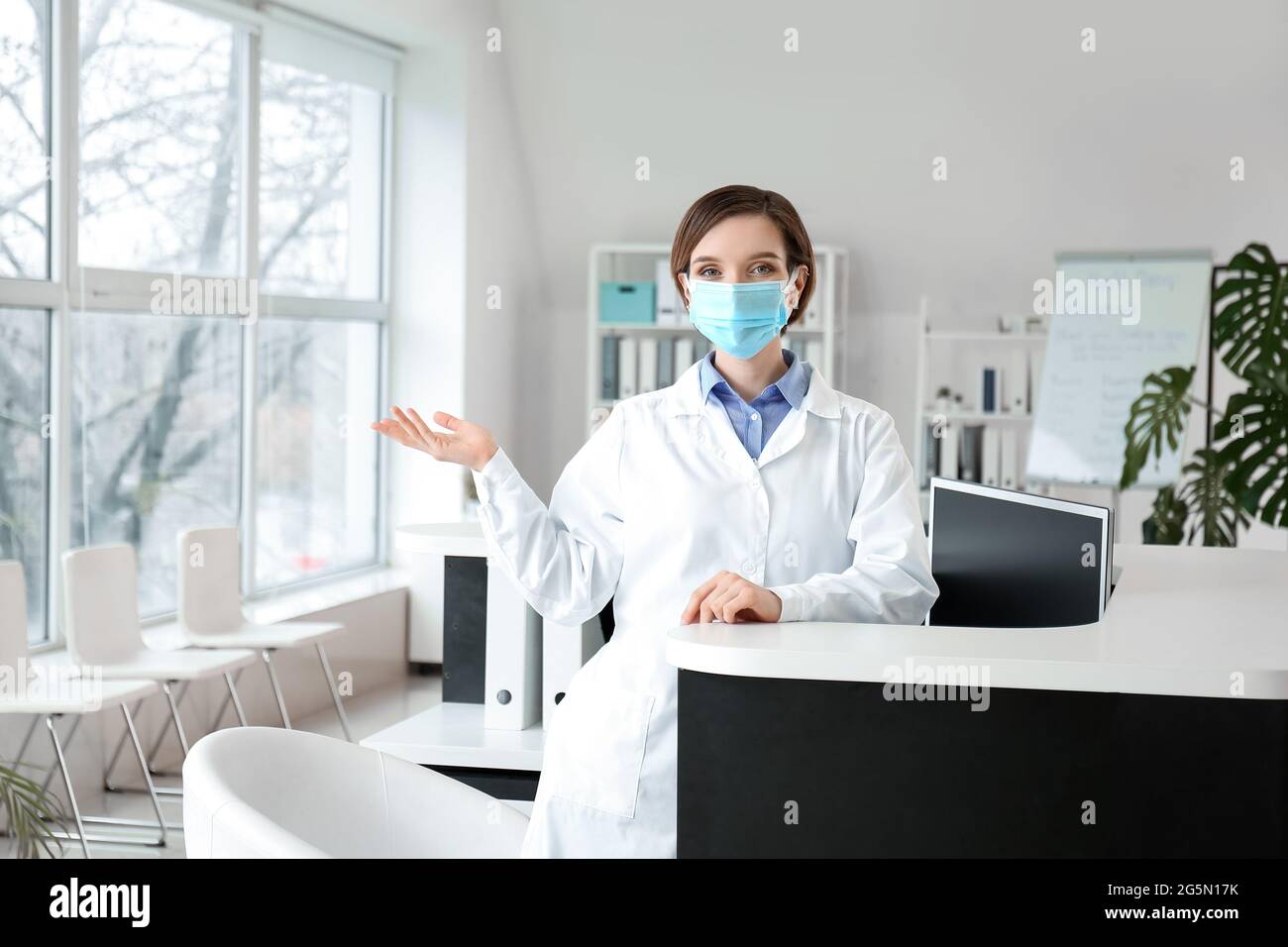 Female medical assistant showing something in clinic Stock Photo - Alamy