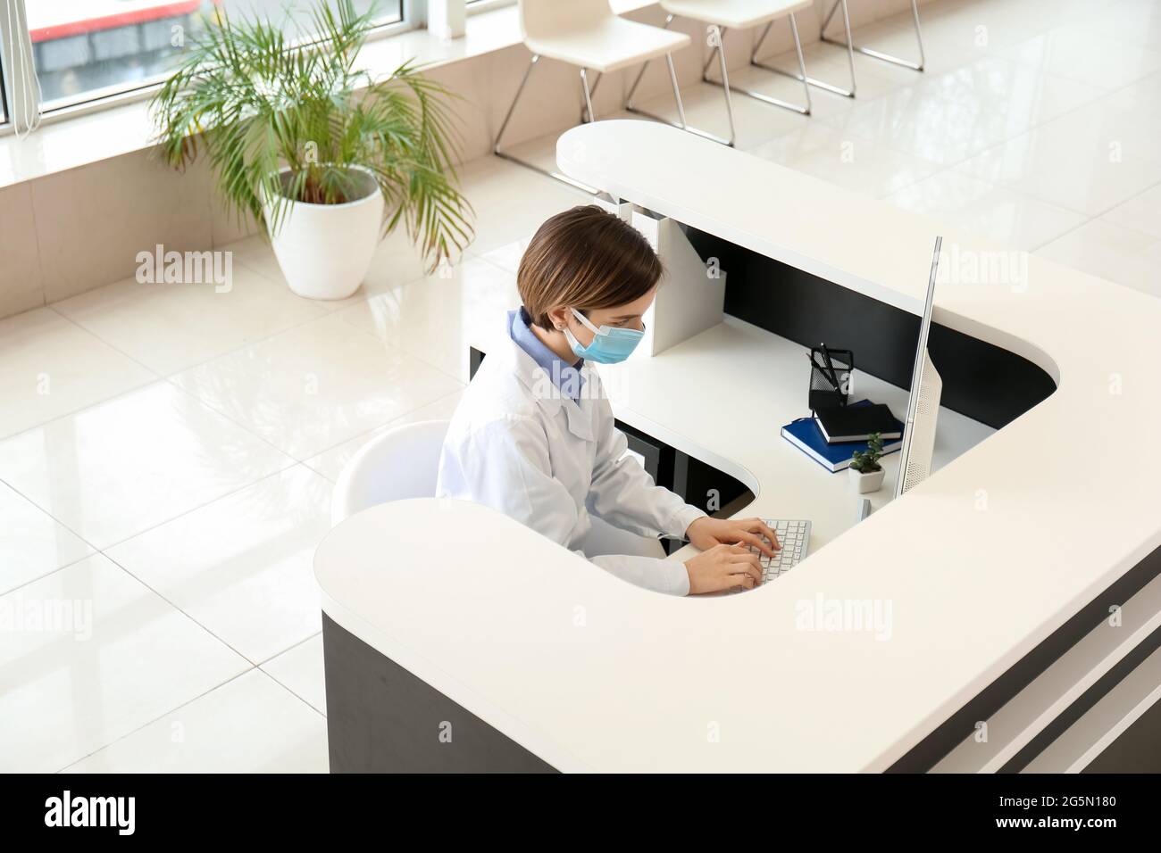 Female medical assistant using computer in clinic Stock Photo - Alamy