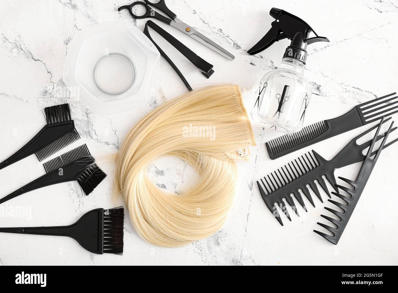 Barber's tools and strand of blonde hair on light background Stock ...