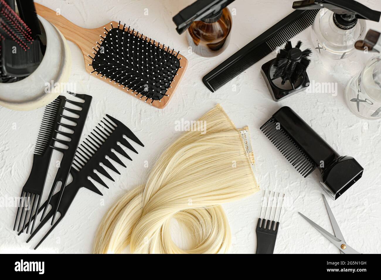 Barber's tools and strand of blonde hair on white background Stock ...