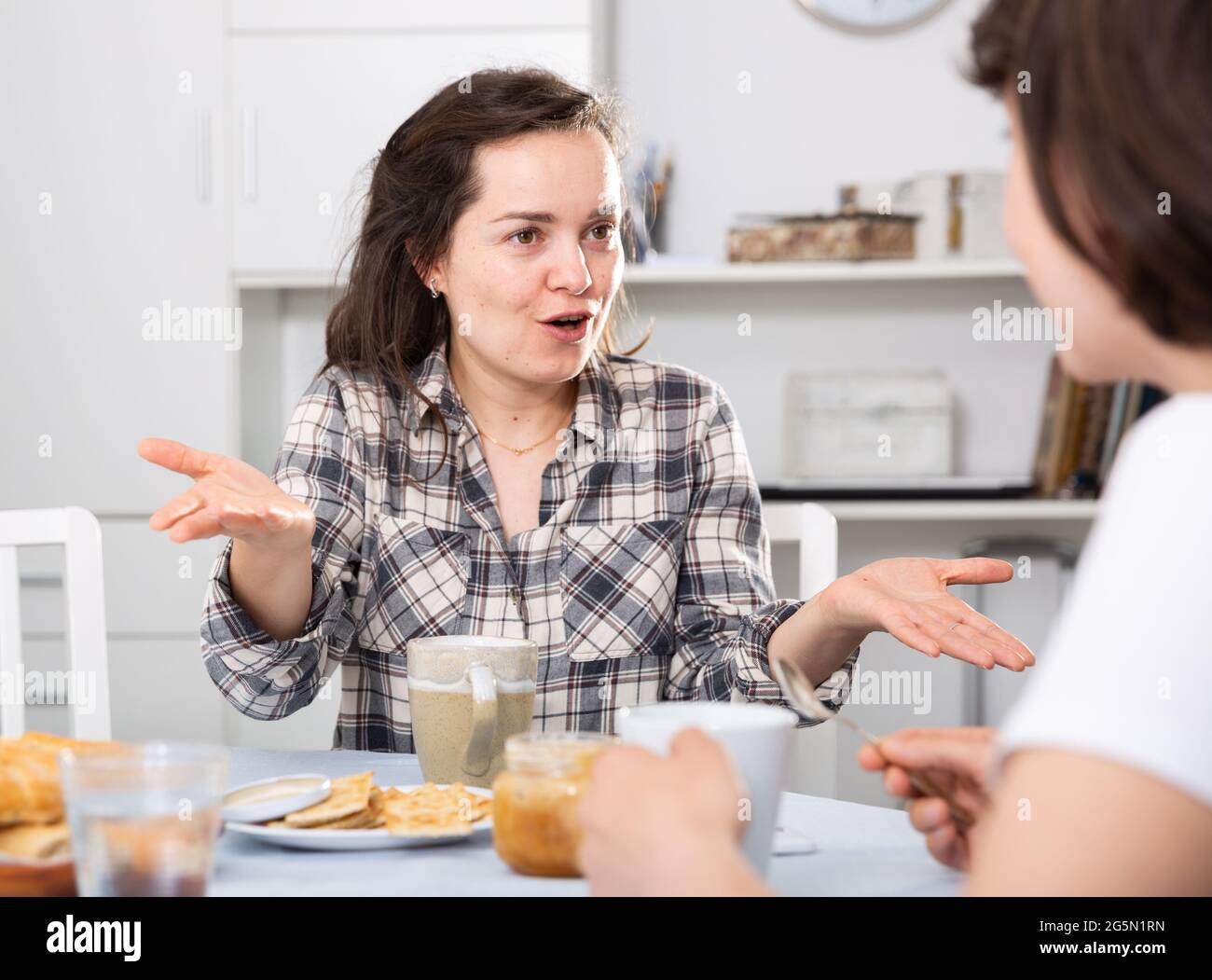 Two woman friends talking and drinking tea in the kitchen Stock Photo ...