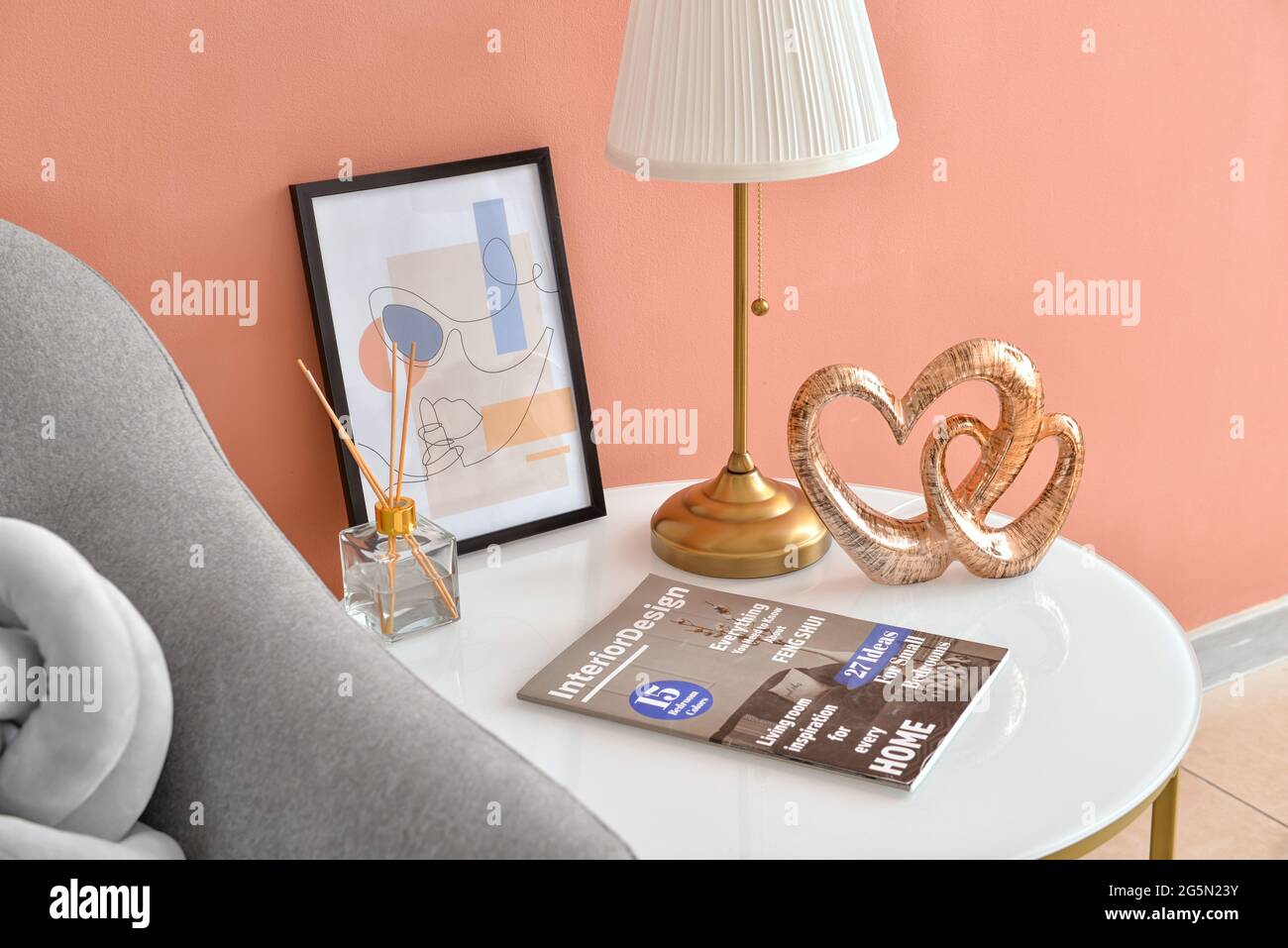 Table with picture and decor near color wall Stock Photo - Alamy