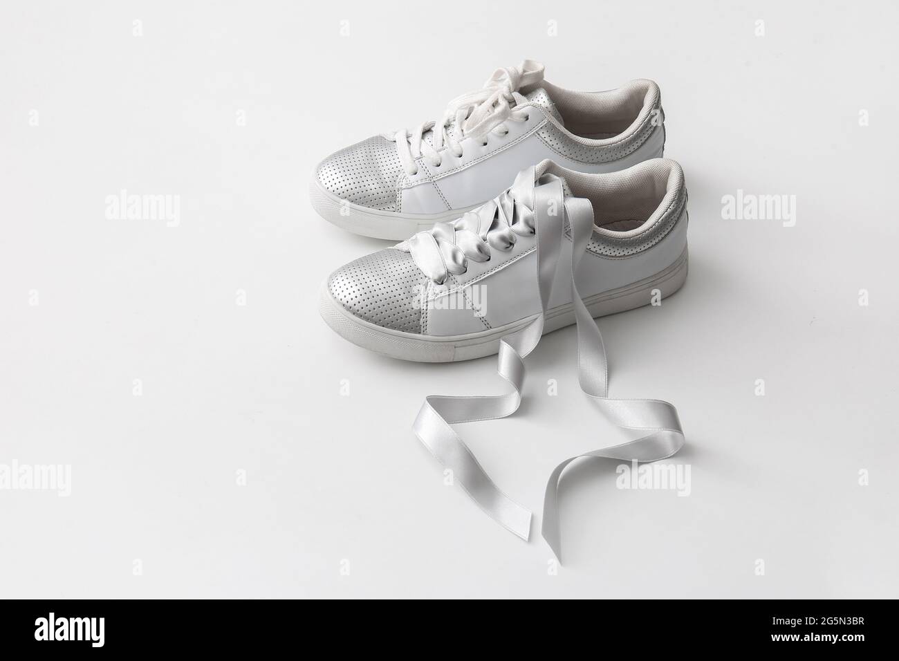 Stylish shoes with silver ribbon on white background Stock Photo - Alamy