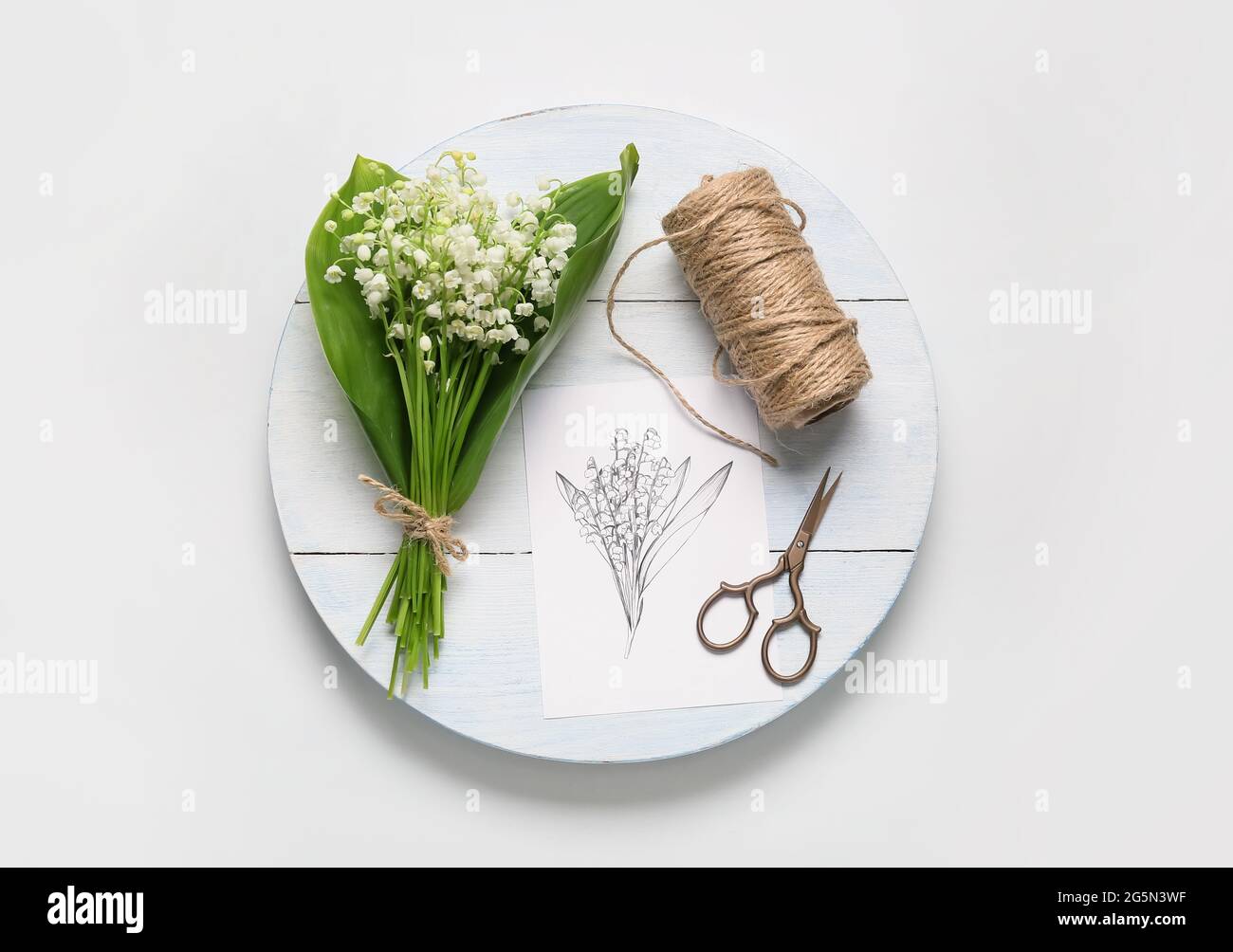 Board with beautiful lily-of-the-valley flowers, rope and greeting card ...