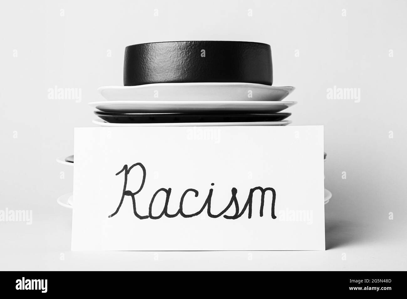 Paper piece with word RACISM and plates on white background Stock Photo ...