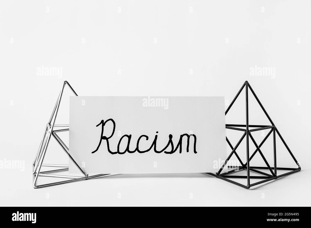 Paper piece with word RACISM and decor on white background Stock Photo ...