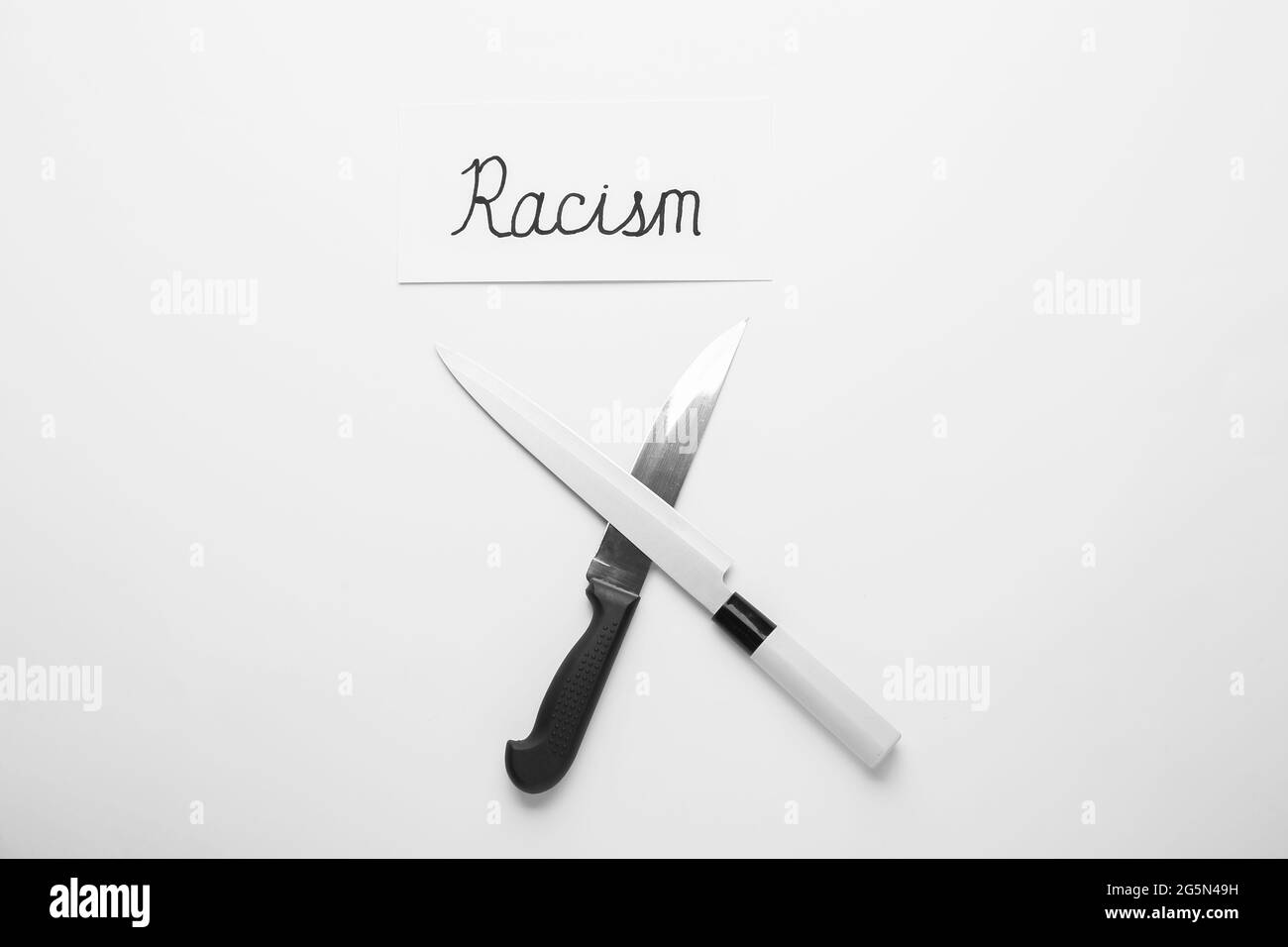 Paper piece with word RACISM and knives on white background Stock Photo ...