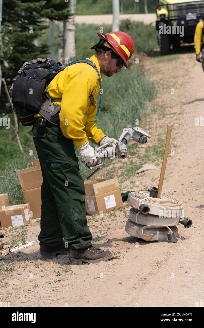 A firefighter assembles gated y connectors fo connect multiple fire ...
