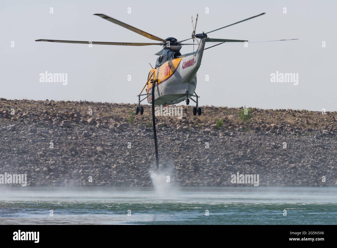 A Sikorsky S-61 fire-fighting helicopter takes off after filling with ...