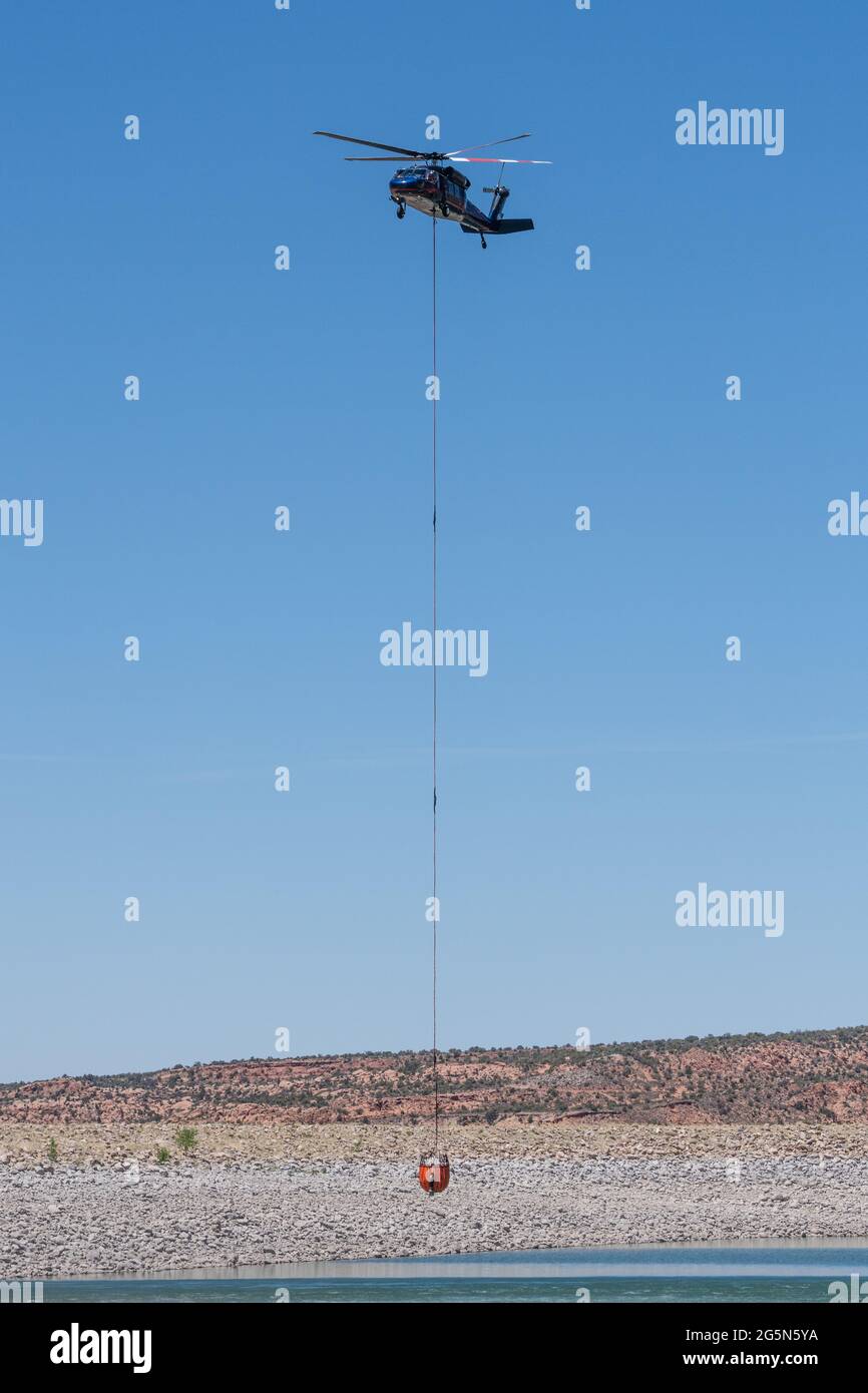 A Sikorsky UH-60 Blackhawk fire-fighting helicopter lifts a helibucket ...