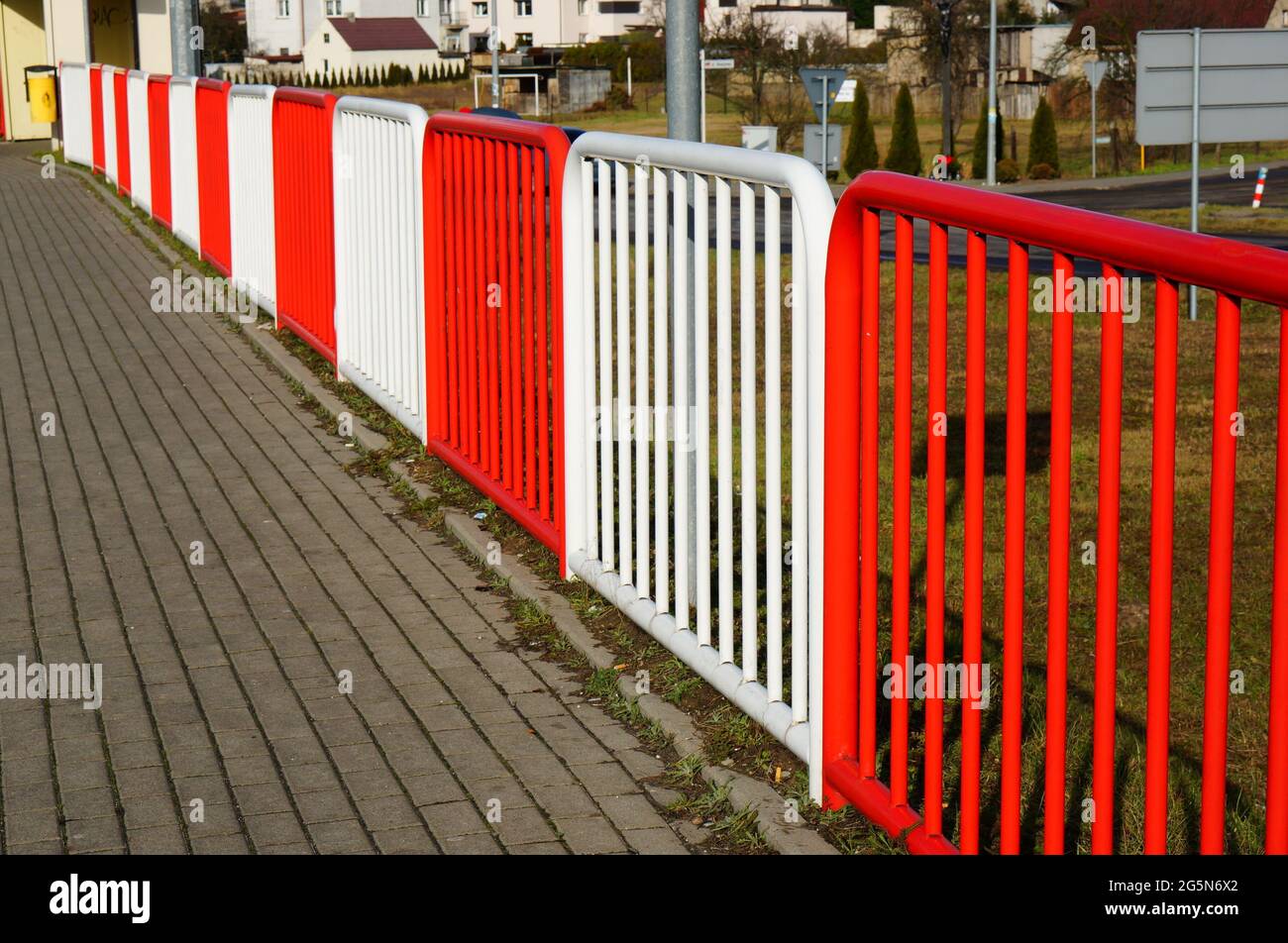 Red and white square fence panel enclosing the buildings and its ...