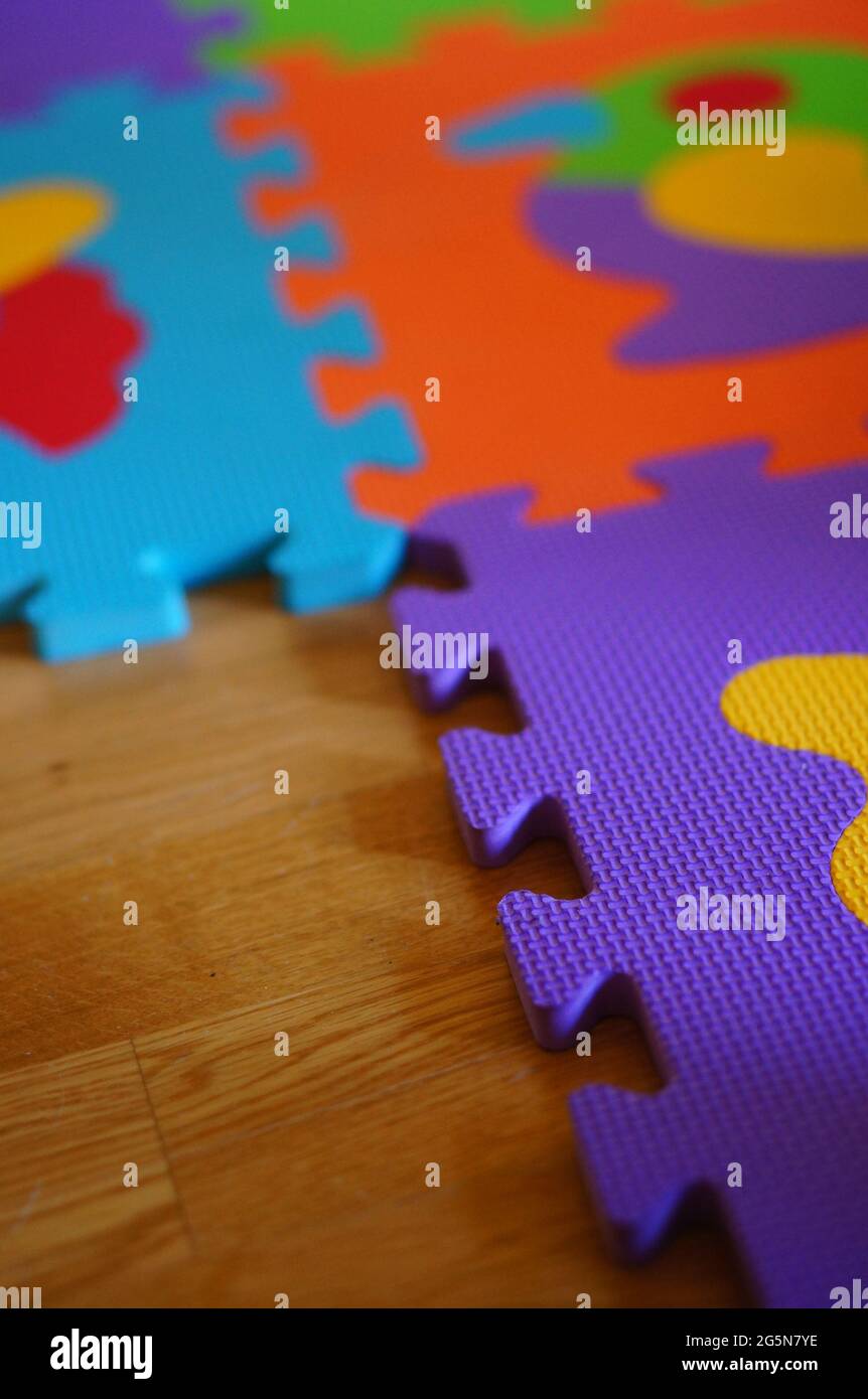 Colorful kids' puzzle mat on a wooden floor Stock Photo - Alamy