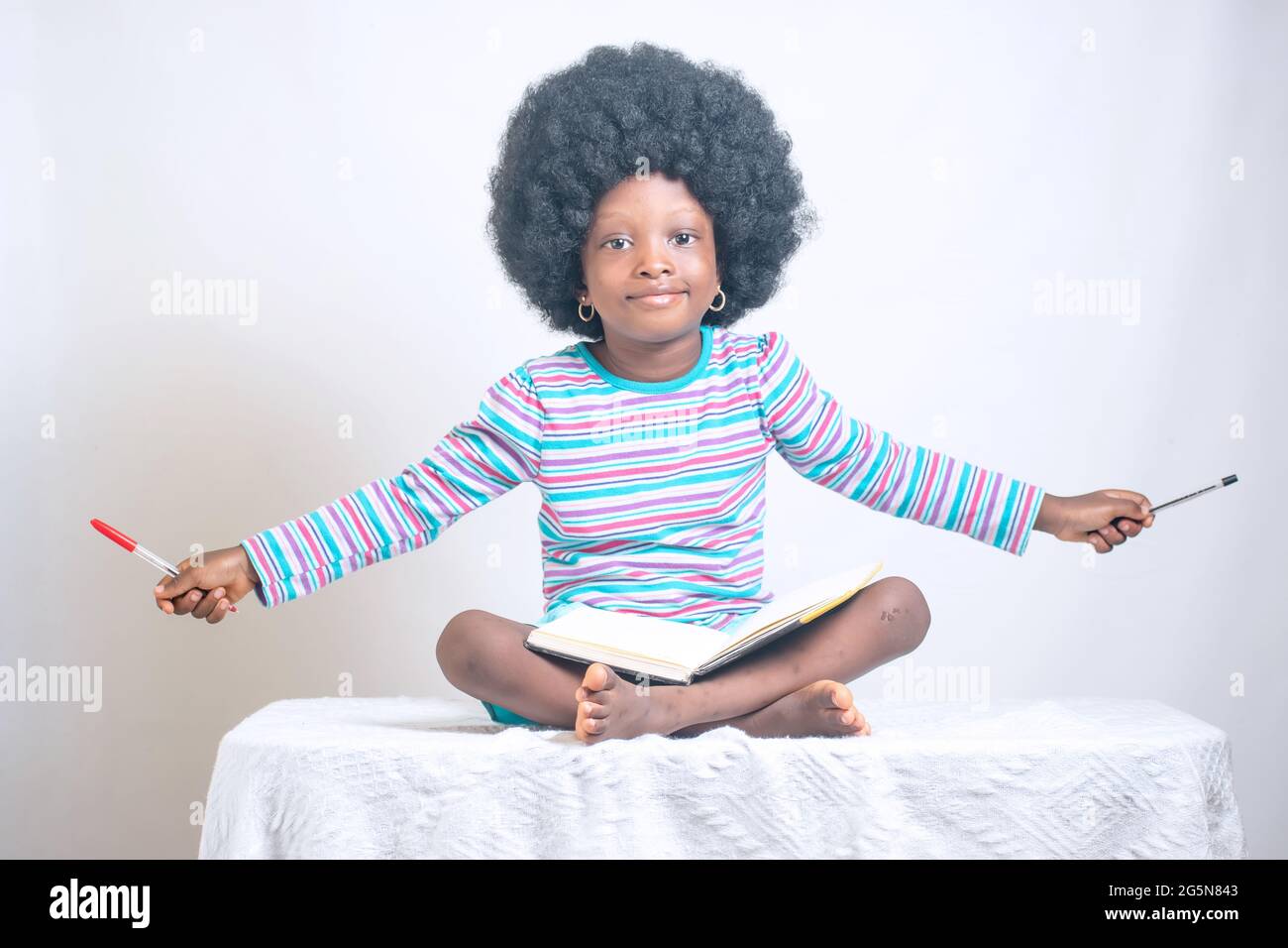 African girl child with an afro hair style shows her love for education ...