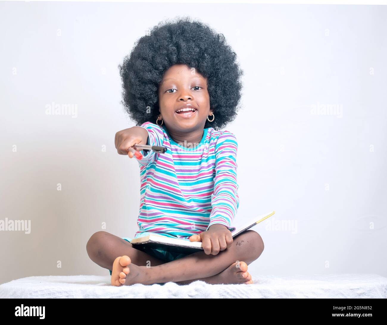 African girl child with an afro hair style shows her love for education ...