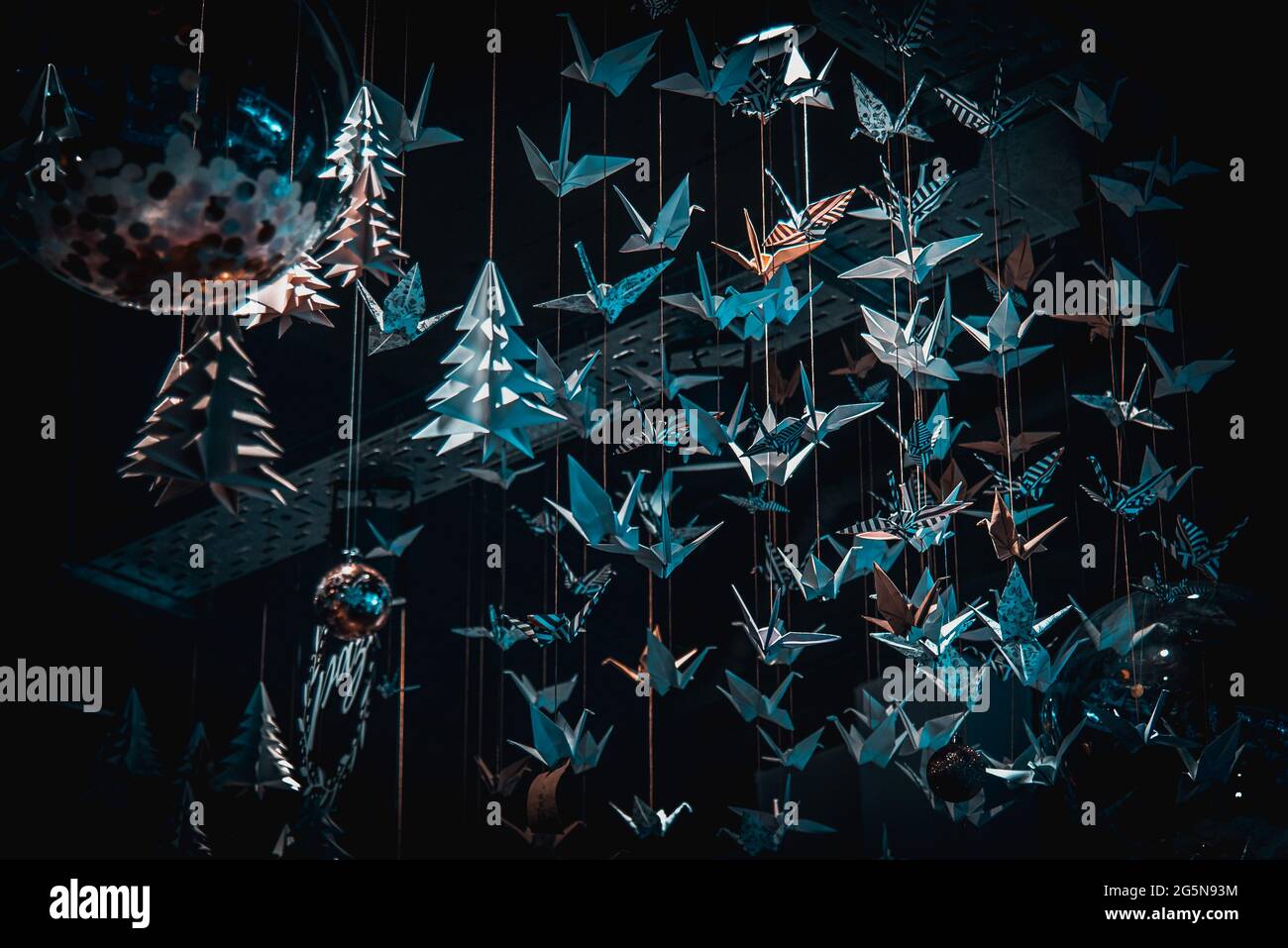 Lots of origami swans hanging from the roof, seen from underneath in a ...