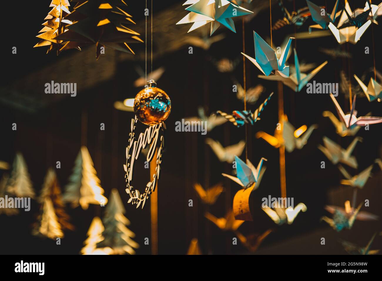 Lots of origami swans hanging from the roof, seen from underneath in a ...