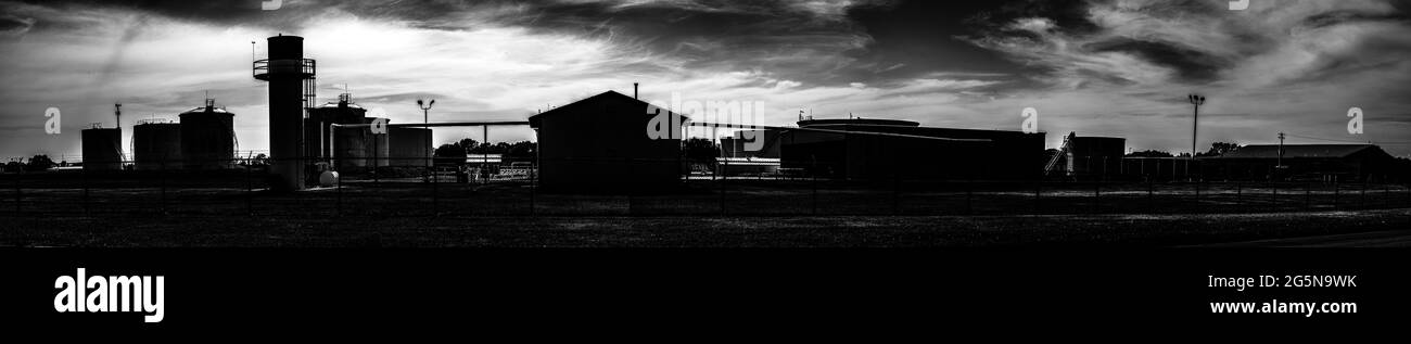 silhouette panoramic generic chemical tank farm with fencing and ...