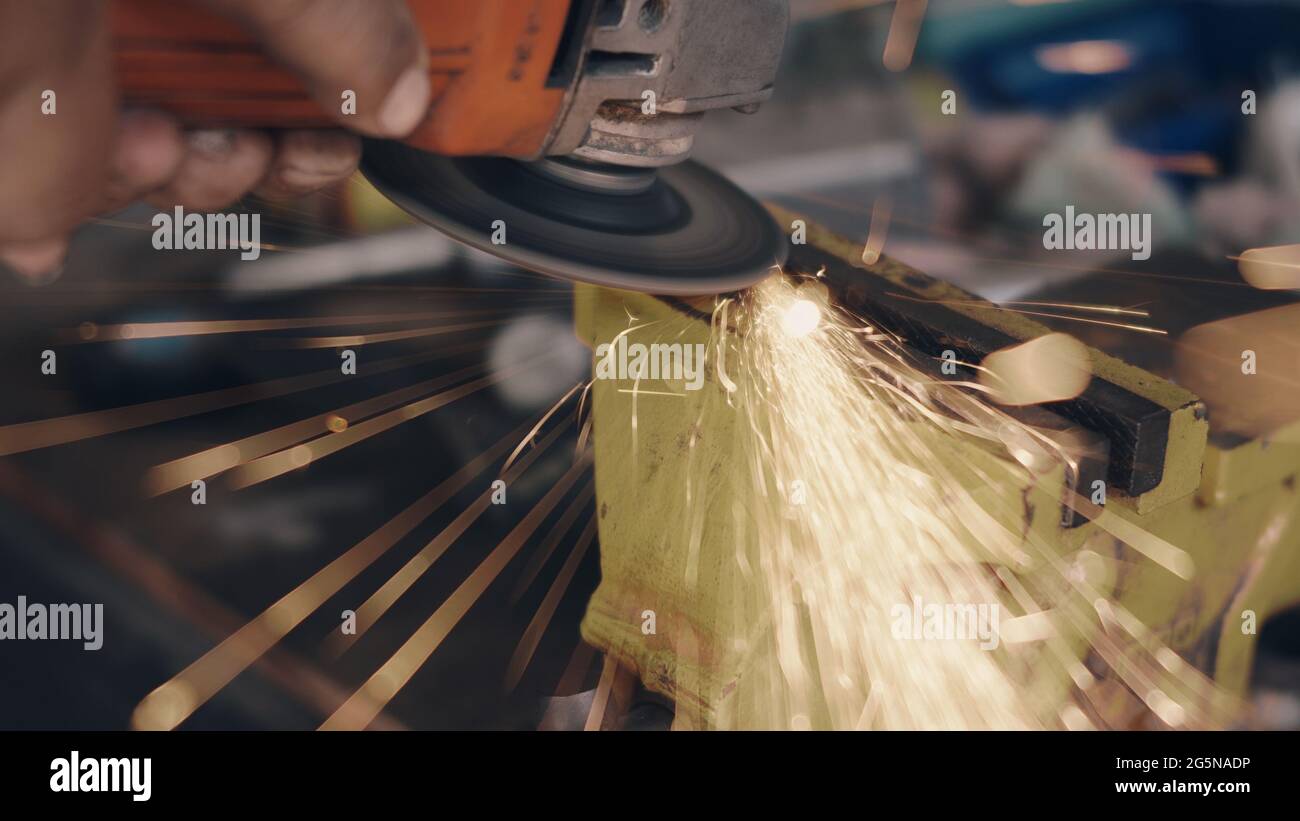 Worker man using electric wheel tool grinding and cutting on steel ...