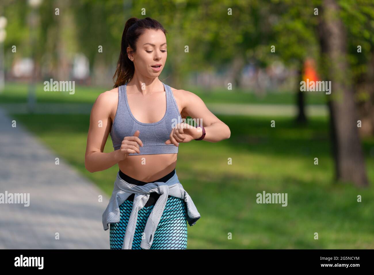 Woman checks her pulse after jogging workout in the park. The concept ...