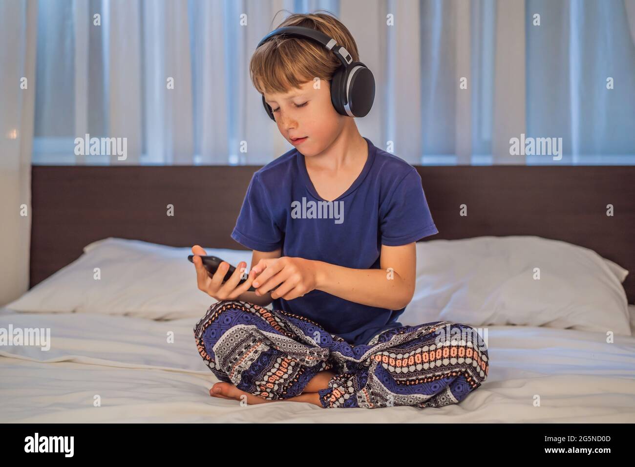 Boy meditates on bed using meditation app. sport, technology and ...