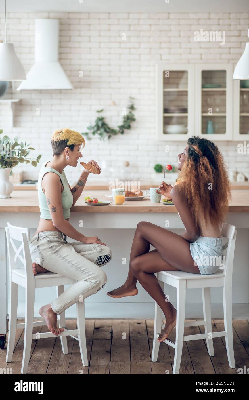 African American And Caucasian Girlfriend Are Relaxed Eating Stock