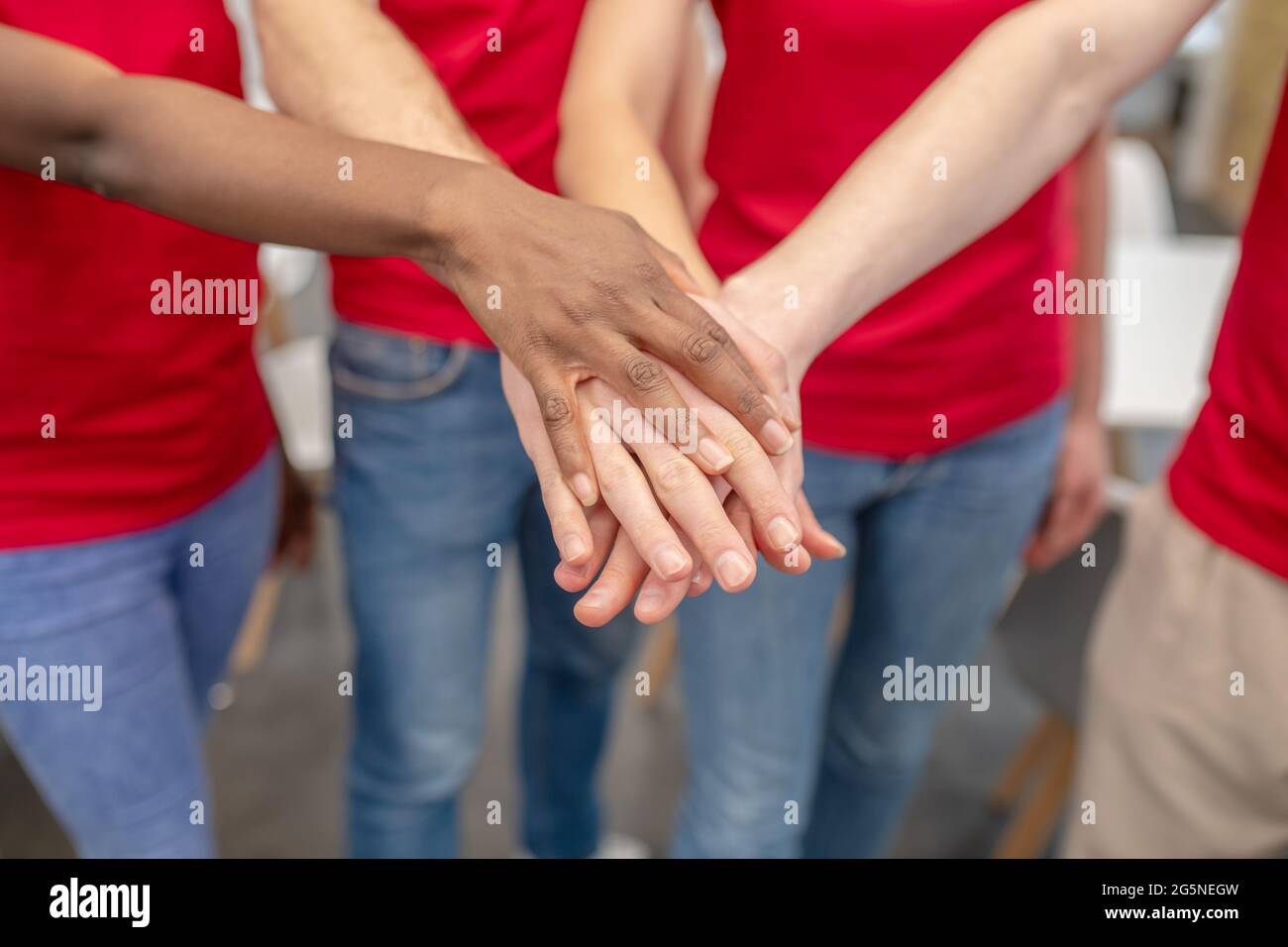 Hands of volunteers in handshake showing unity Stock Photo - Alamy