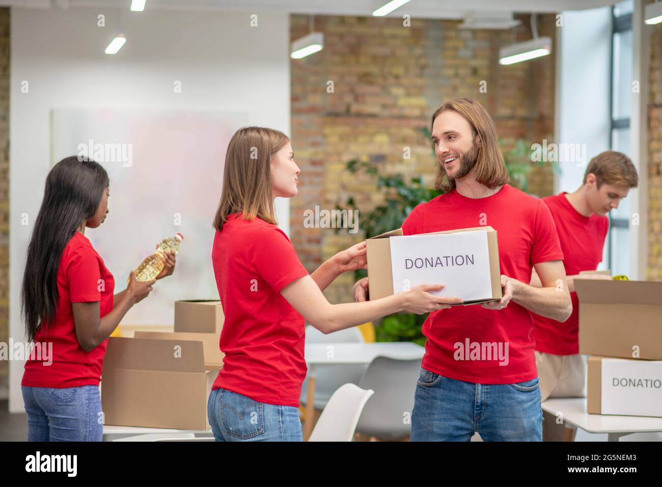 Group of young volunteers packing donations in boxes Stock Photo - Alamy
